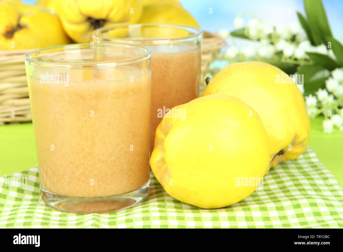 Sweet quince with juice on table on light blue background Stock Photo ...
