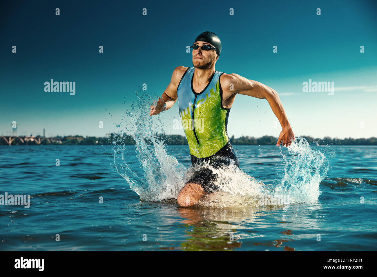 Professional triathlete swimming in river's open water. Man wearing ...