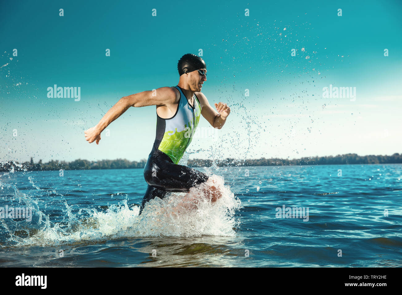 Professional triathlete swimming in river's open water. Man wearing ...