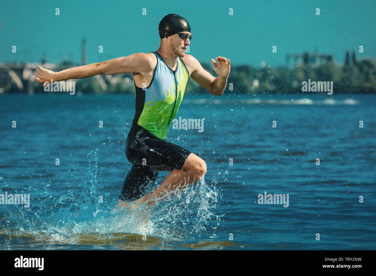 Professional triathlete swimming in river's open water. Man wearing ...