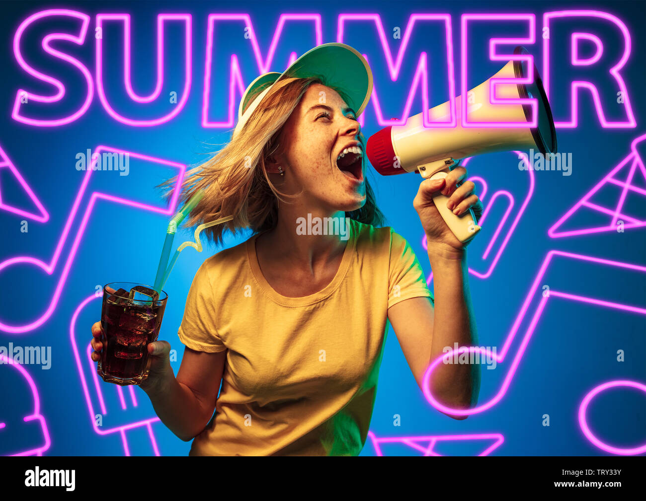 Female model in trendy neon light on blue background. Modern design ...