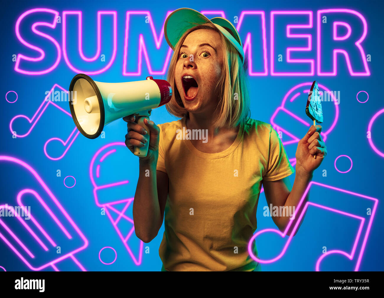 Female model in trendy neon light on blue background. Modern design ...