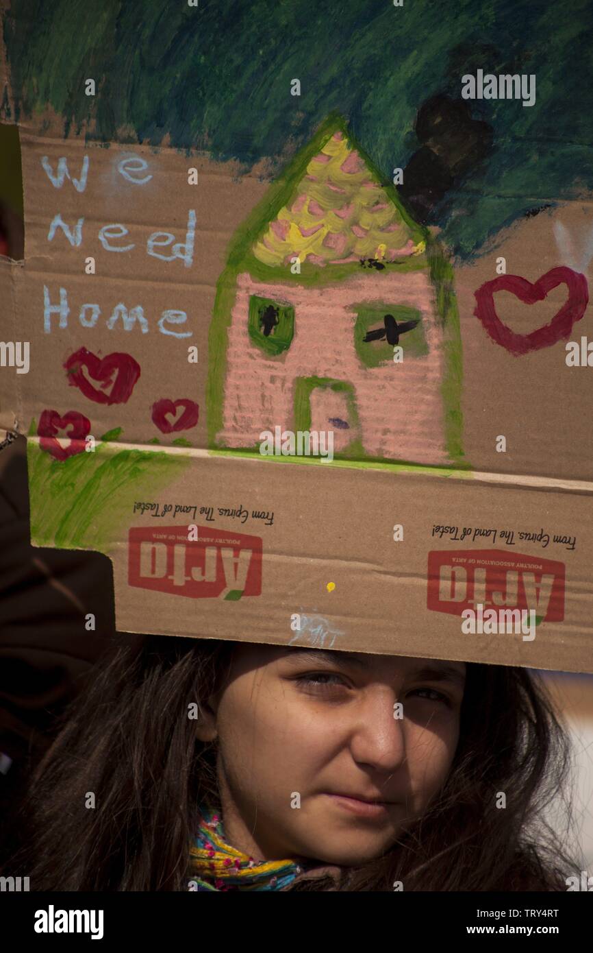 Refugee girl with sign "We need home". Refugees from occupied house ...