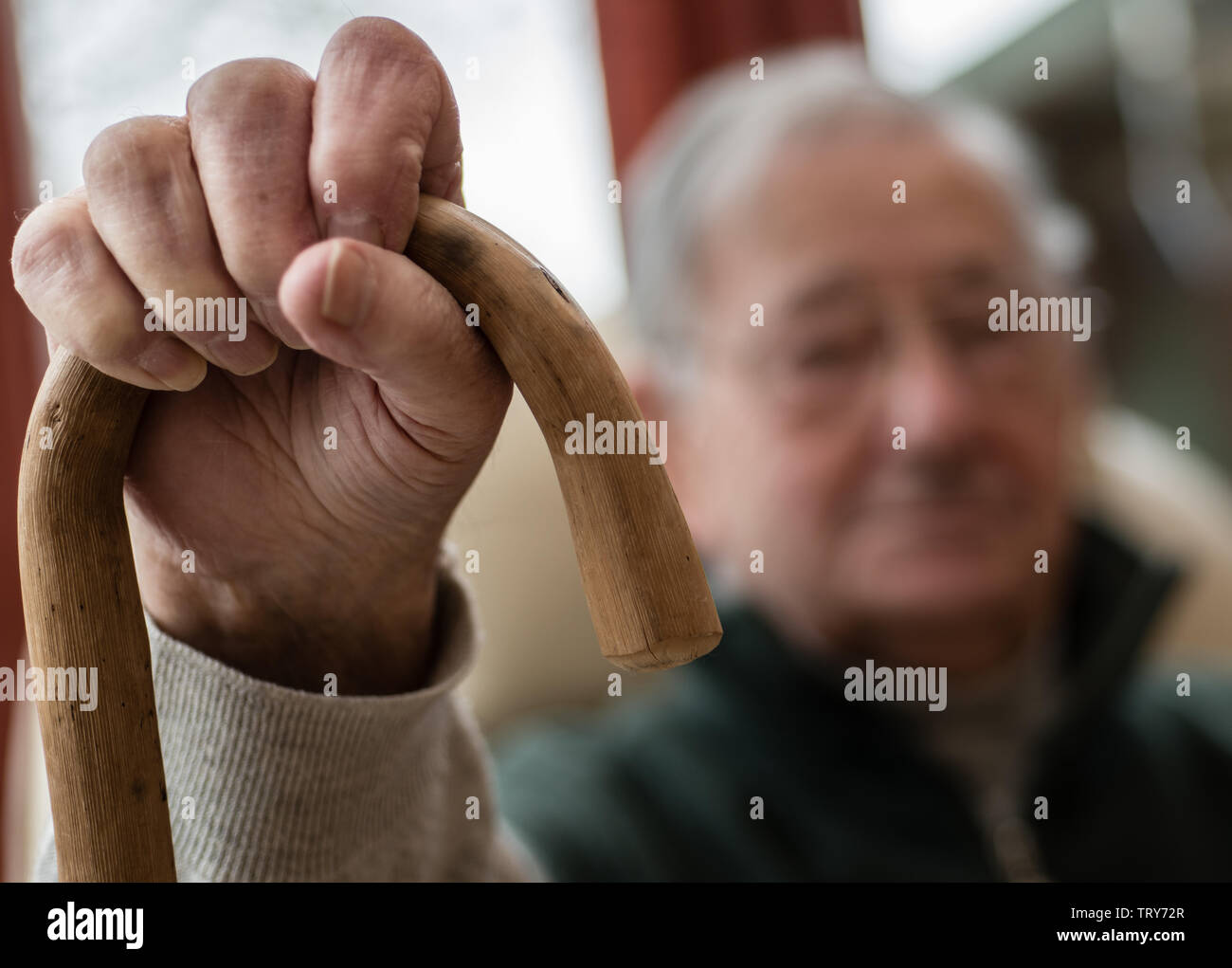 Old man holding walking stick hi-res stock photography and images - Alamy