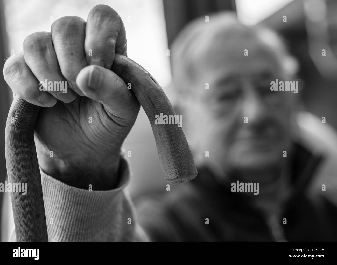 Old man holding walking stick hi-res stock photography and images - Alamy