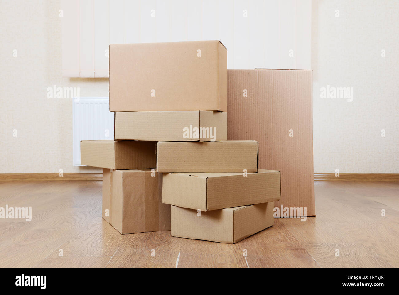 Empty room with stack of cartons: moving house concept Stock Photo - Alamy