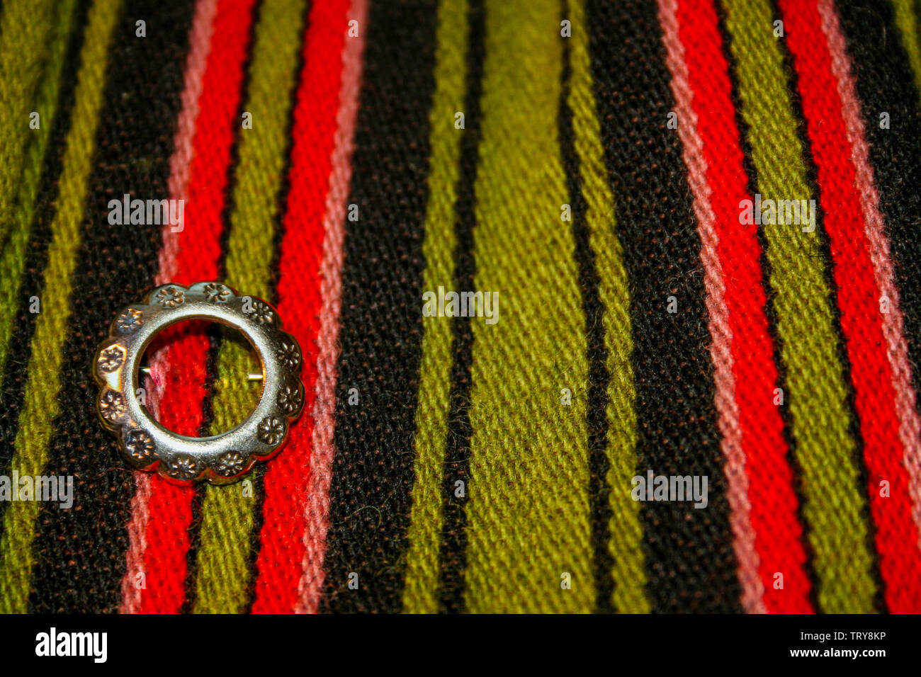 Latvian traditional brooch on a colorful traditional Latvian folk ...