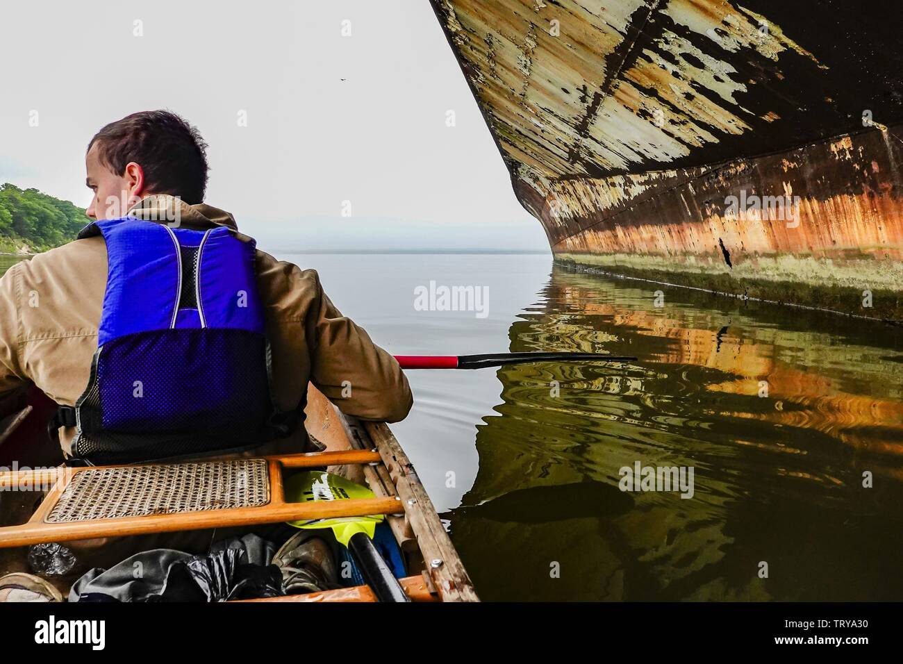 Mallows Bay, Maryland USA A young man canoeing through the ghost fleet ...