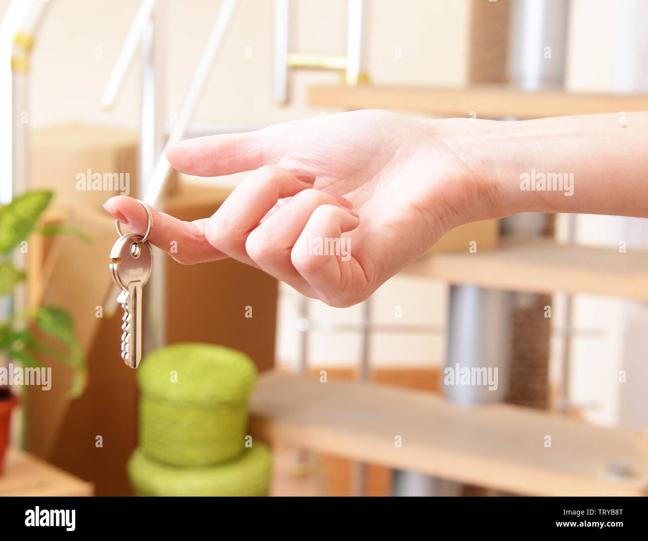 Female hand with keys ob stack of cartons background: moving house ...