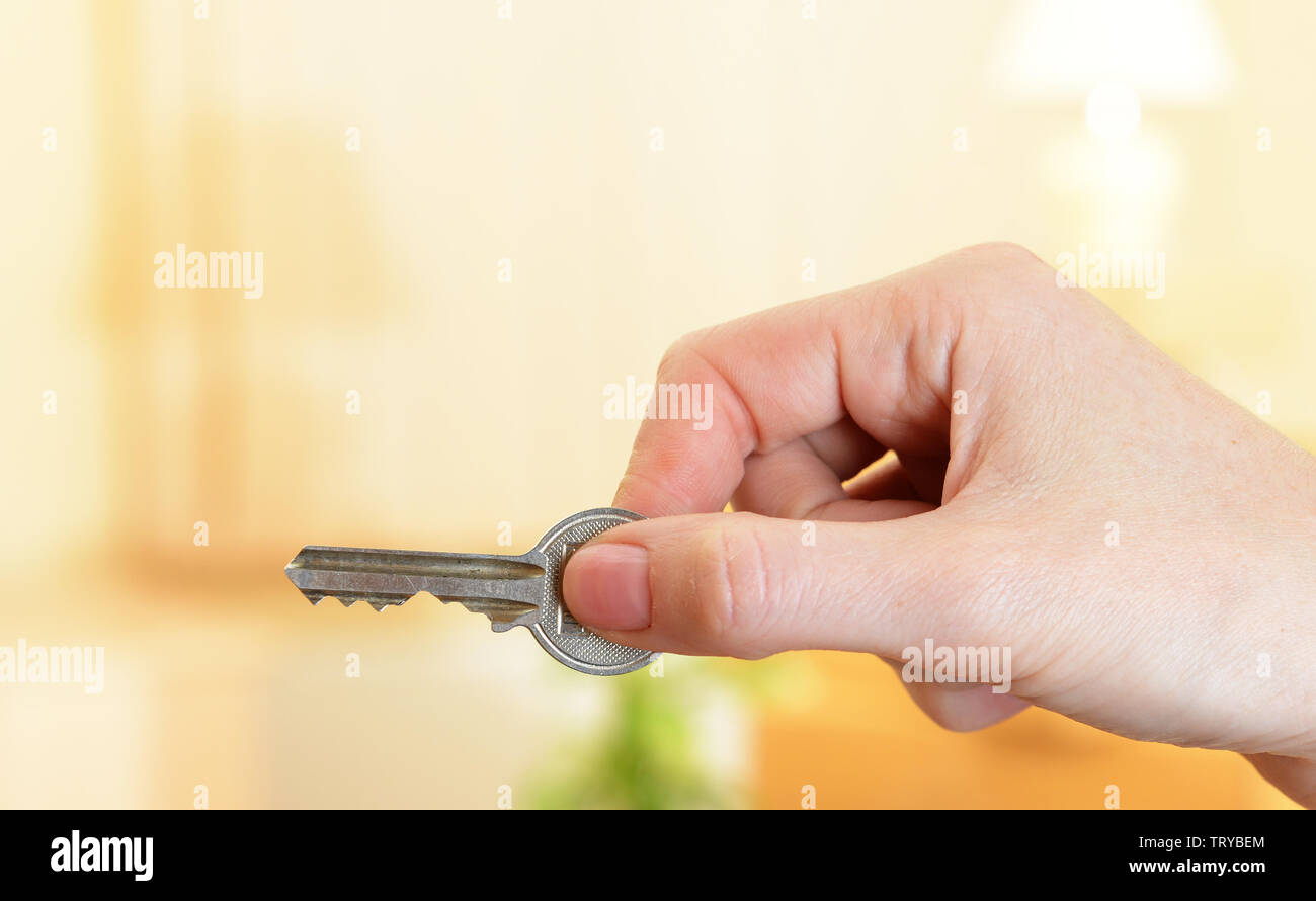 Female hand with keys ob stack of cartons background: moving house ...