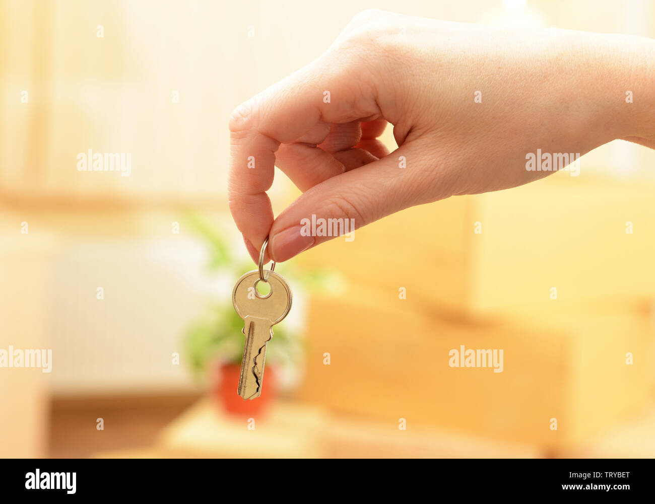 Female hand with keys ob stack of cartons background: moving house ...