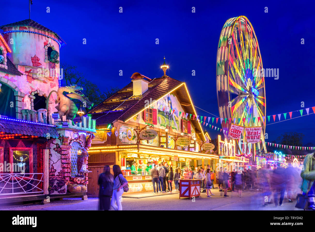 Colorful illuminated fairground attractions on funfair in Augsburg ...