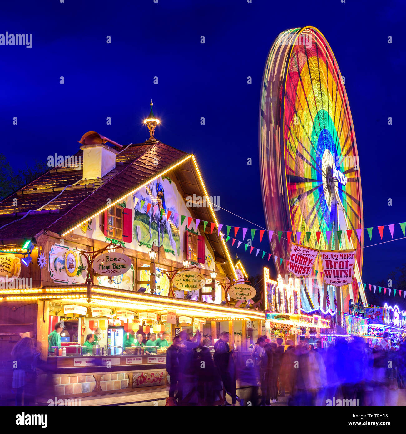 Colorful illuminated fairground attractions on funfair in Augsburg ...