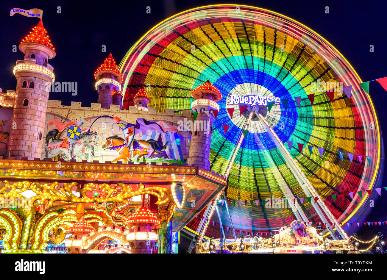 Colorful illuminated fairground attractions on funfair in Augsburg ...