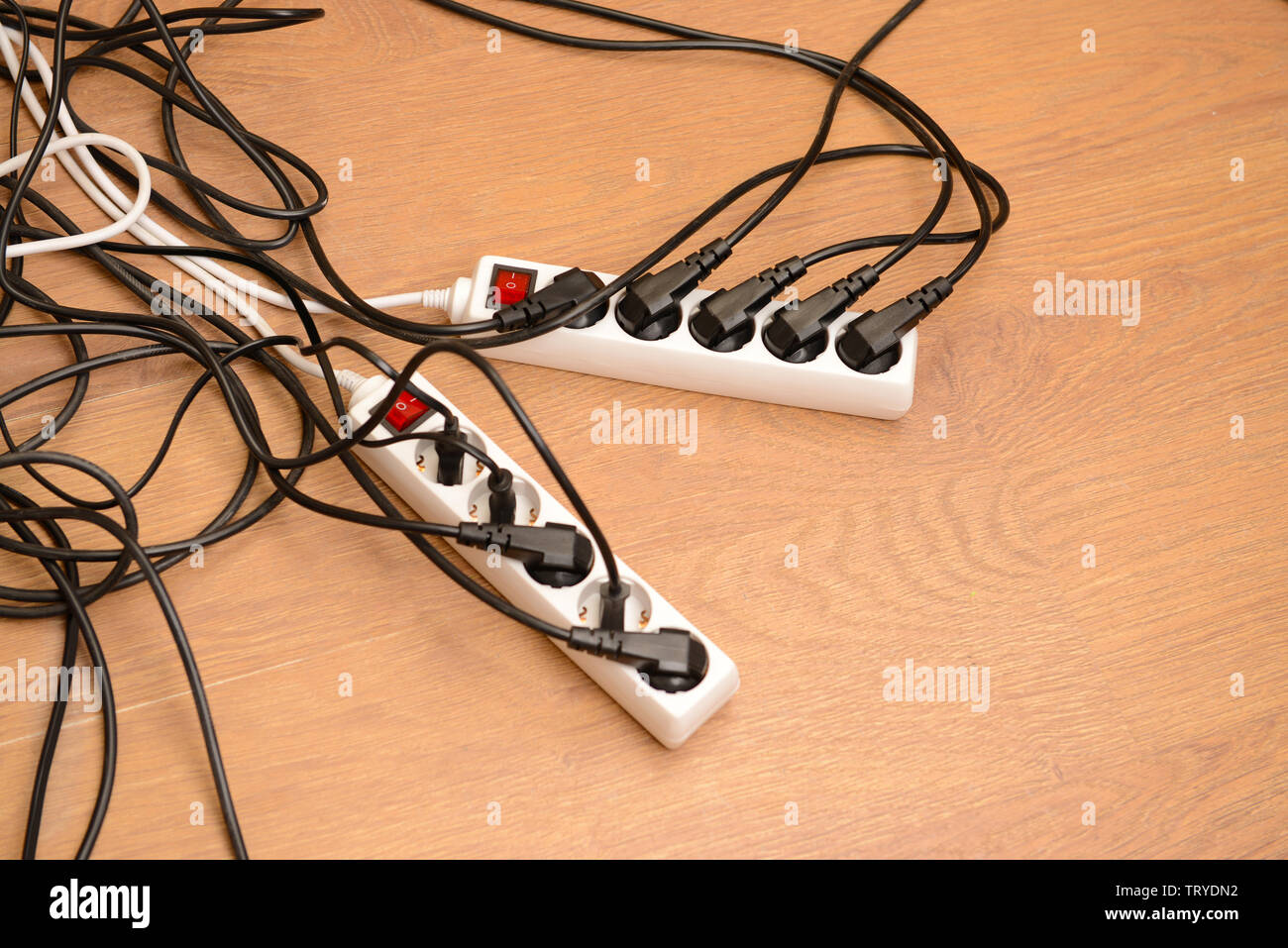 Overloaded power boards, on wooden floor background Stock Photo - Alamy