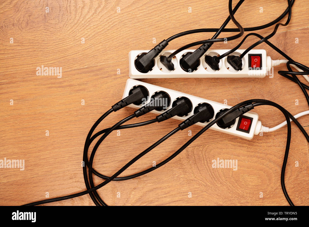 Overloaded power boards, on wooden floor background Stock Photo - Alamy