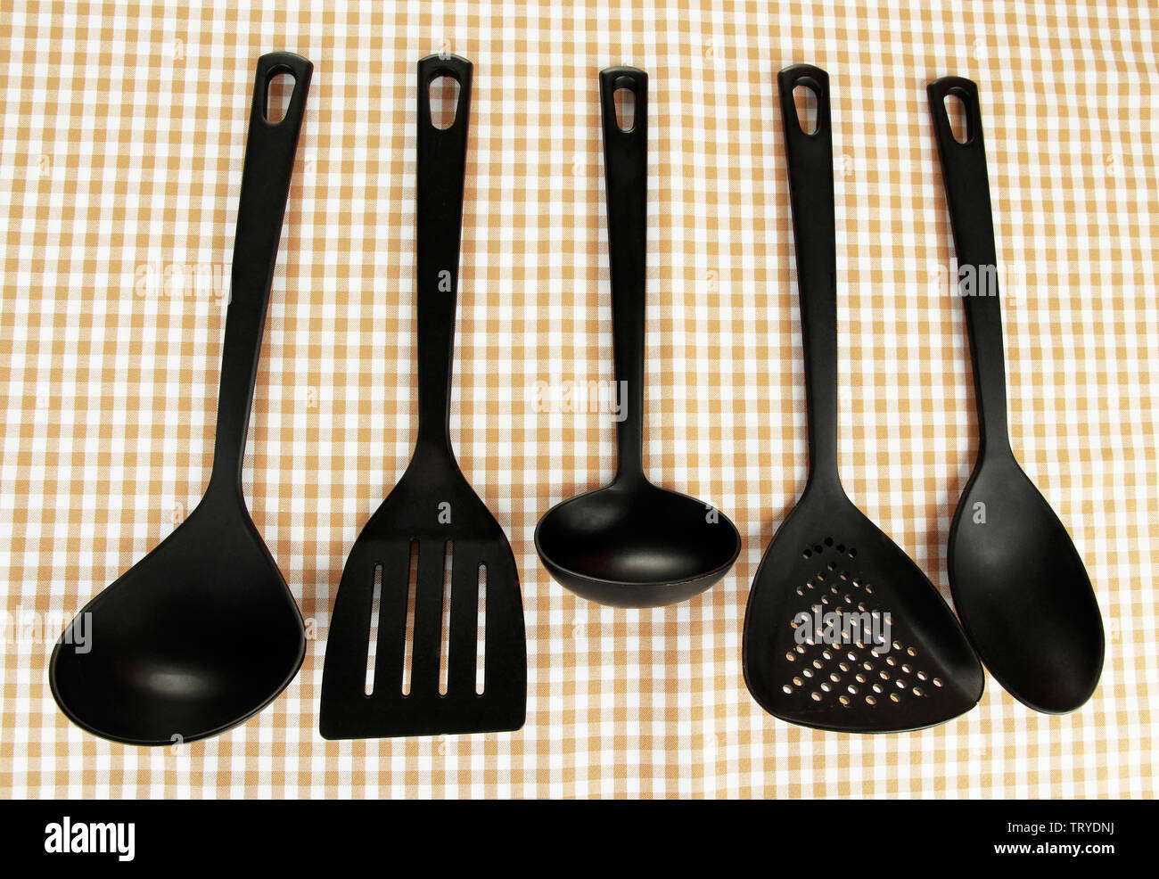 Plastic kitchen utensils on fabric background Stock Photo - Alamy