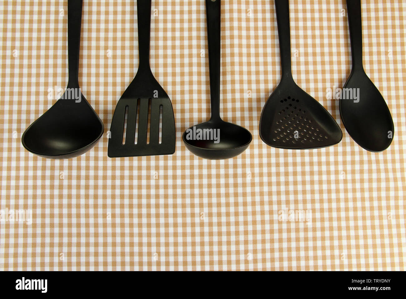 Plastic kitchen utensils on fabric background Stock Photo - Alamy