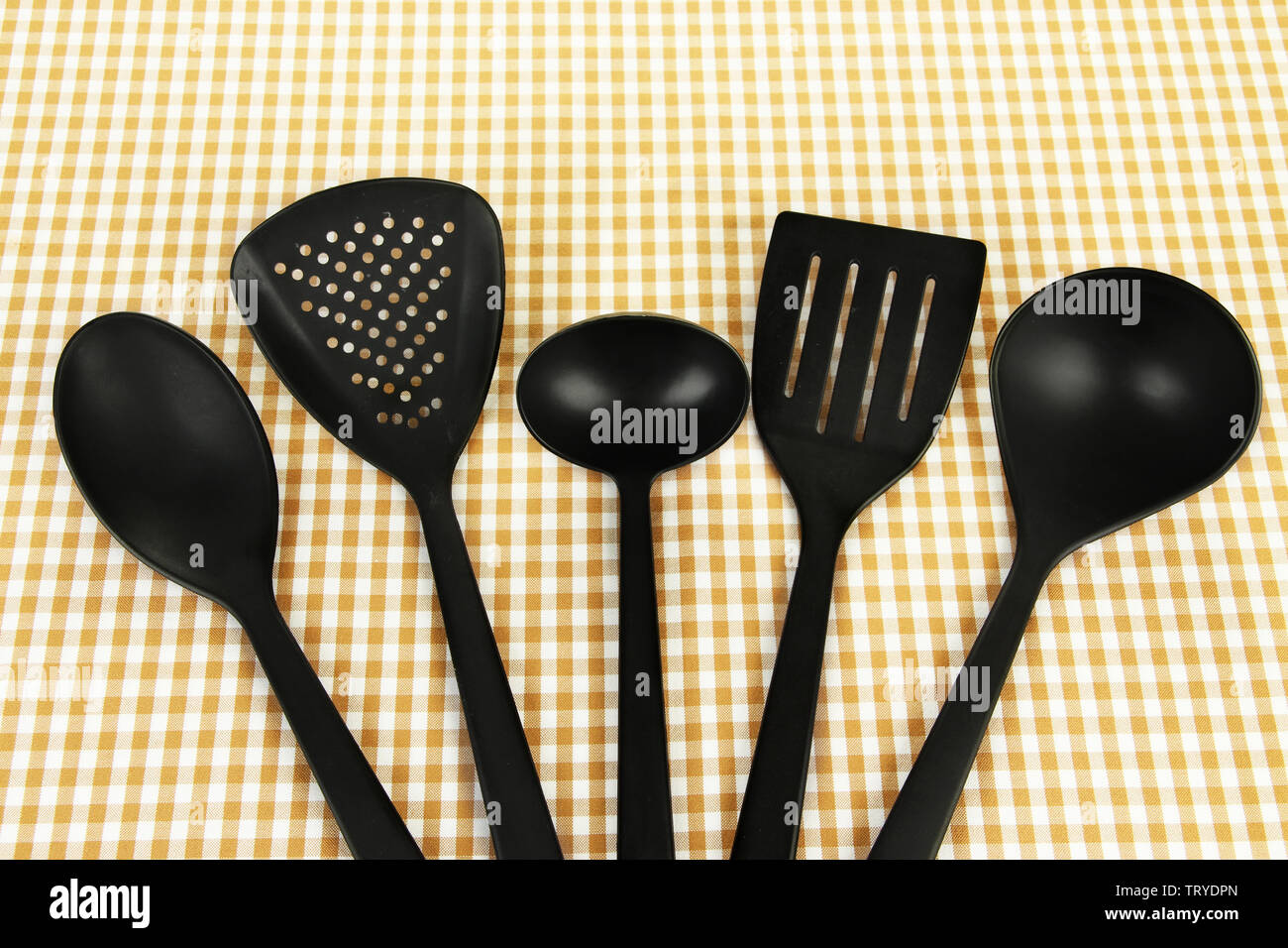 Plastic kitchen utensils on fabric background Stock Photo - Alamy