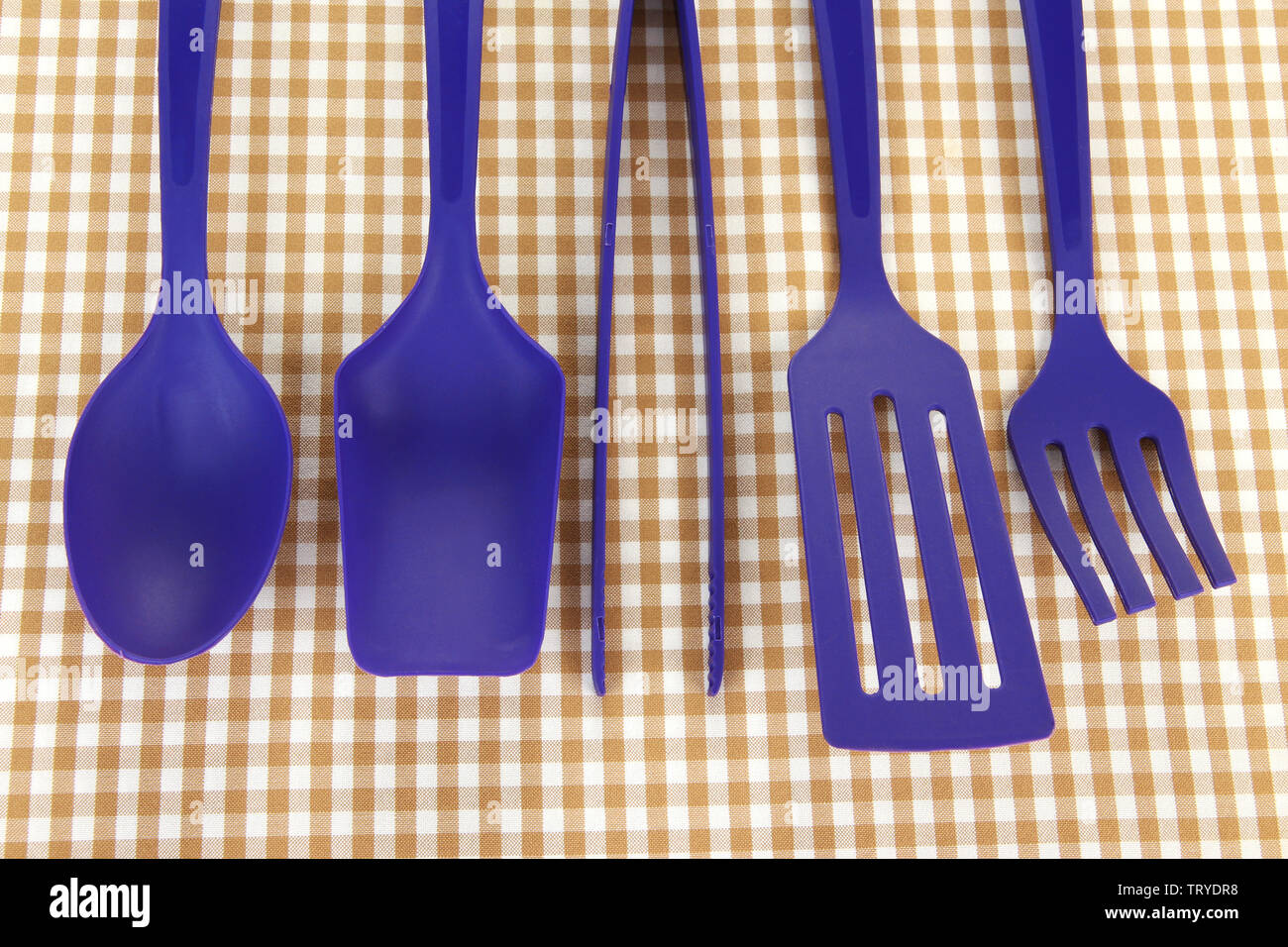 Plastic kitchen utensils on fabric background Stock Photo - Alamy