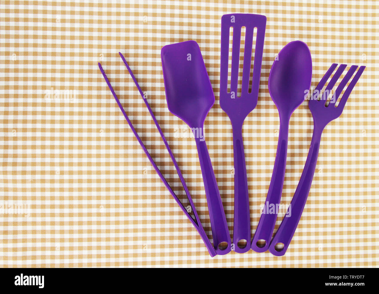 Plastic kitchen utensils on fabric background Stock Photo - Alamy