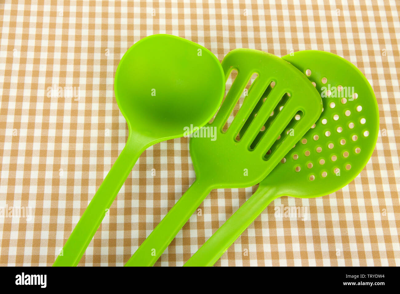 Plastic kitchen utensils on fabric background Stock Photo - Alamy