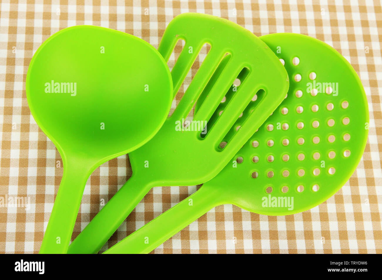 Plastic kitchen utensils on fabric background Stock Photo - Alamy