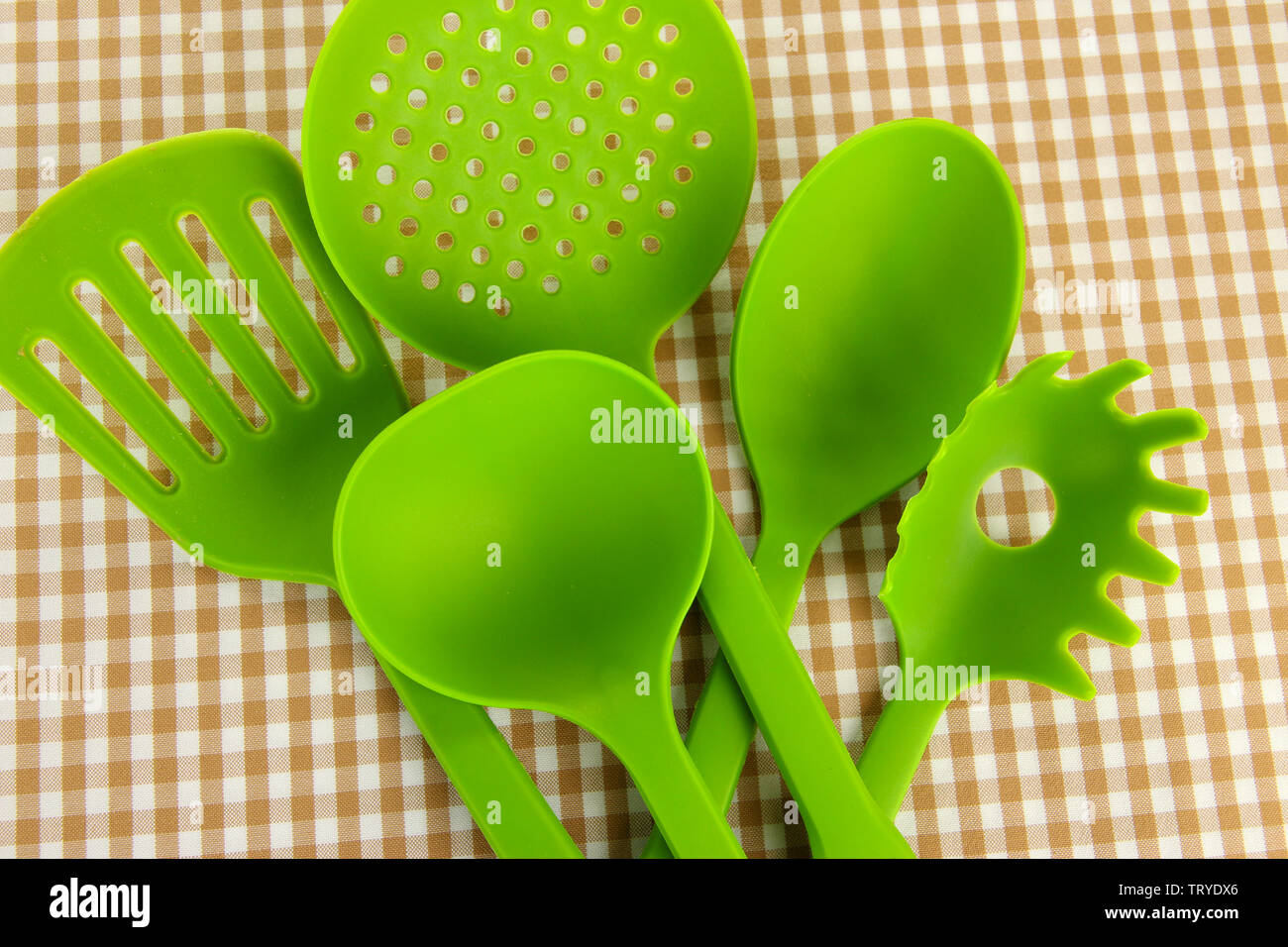 Plastic kitchen utensils on fabric background Stock Photo - Alamy