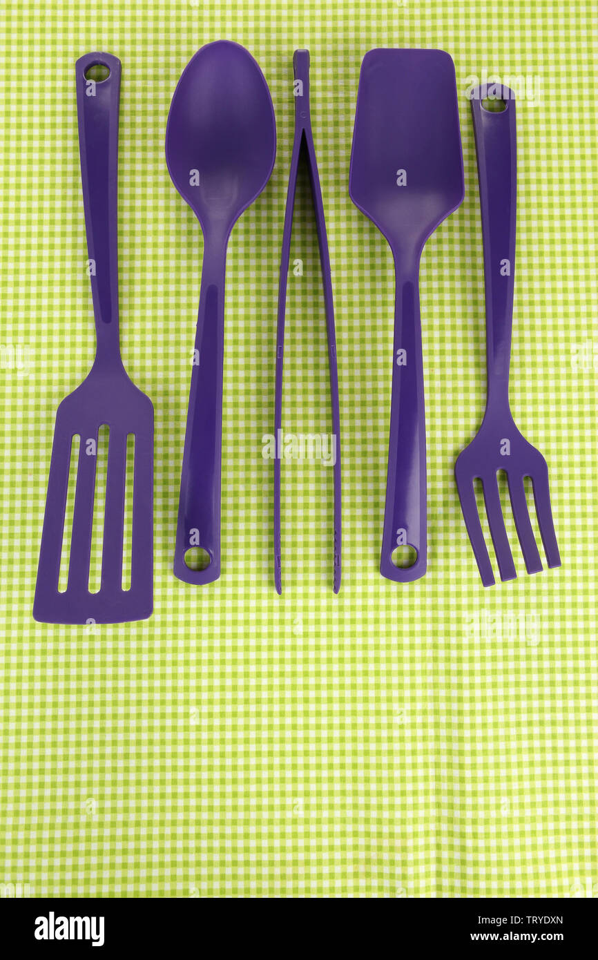 Plastic kitchen utensils on fabric background Stock Photo - Alamy