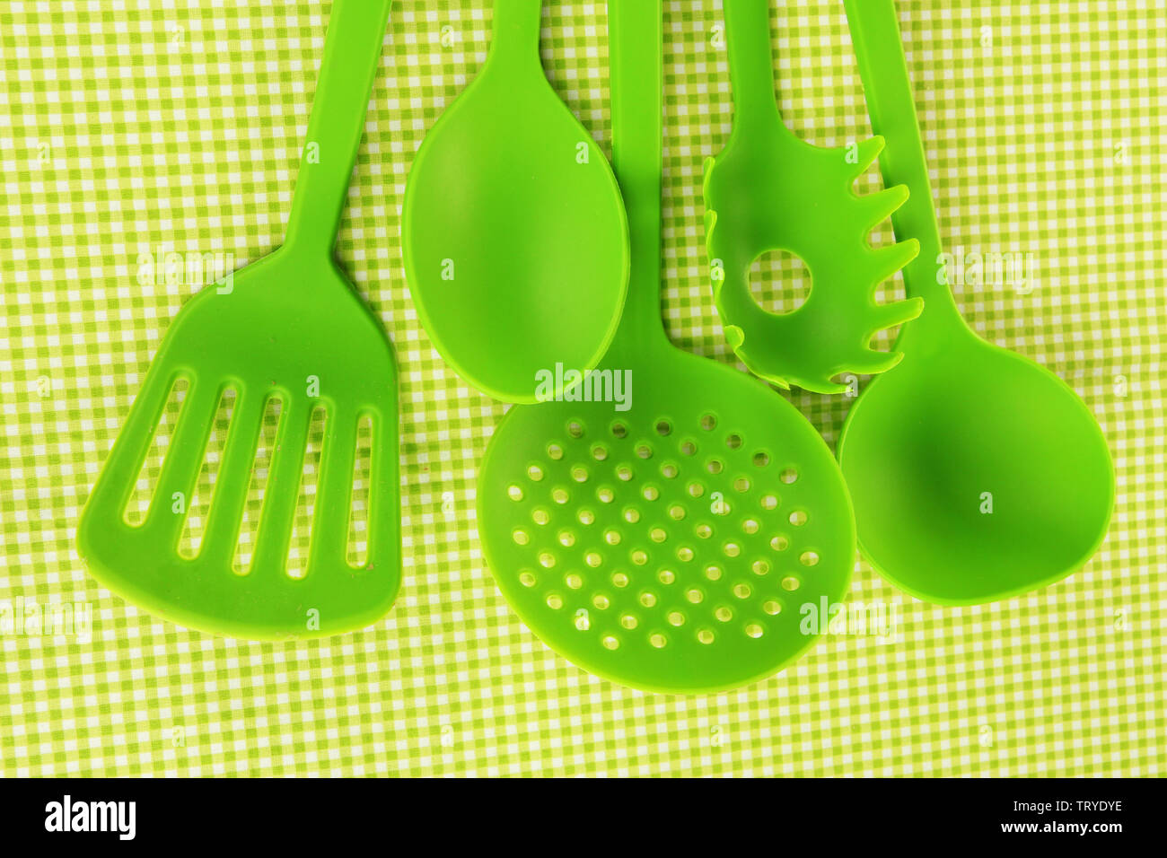 Plastic kitchen utensils on fabric background Stock Photo - Alamy