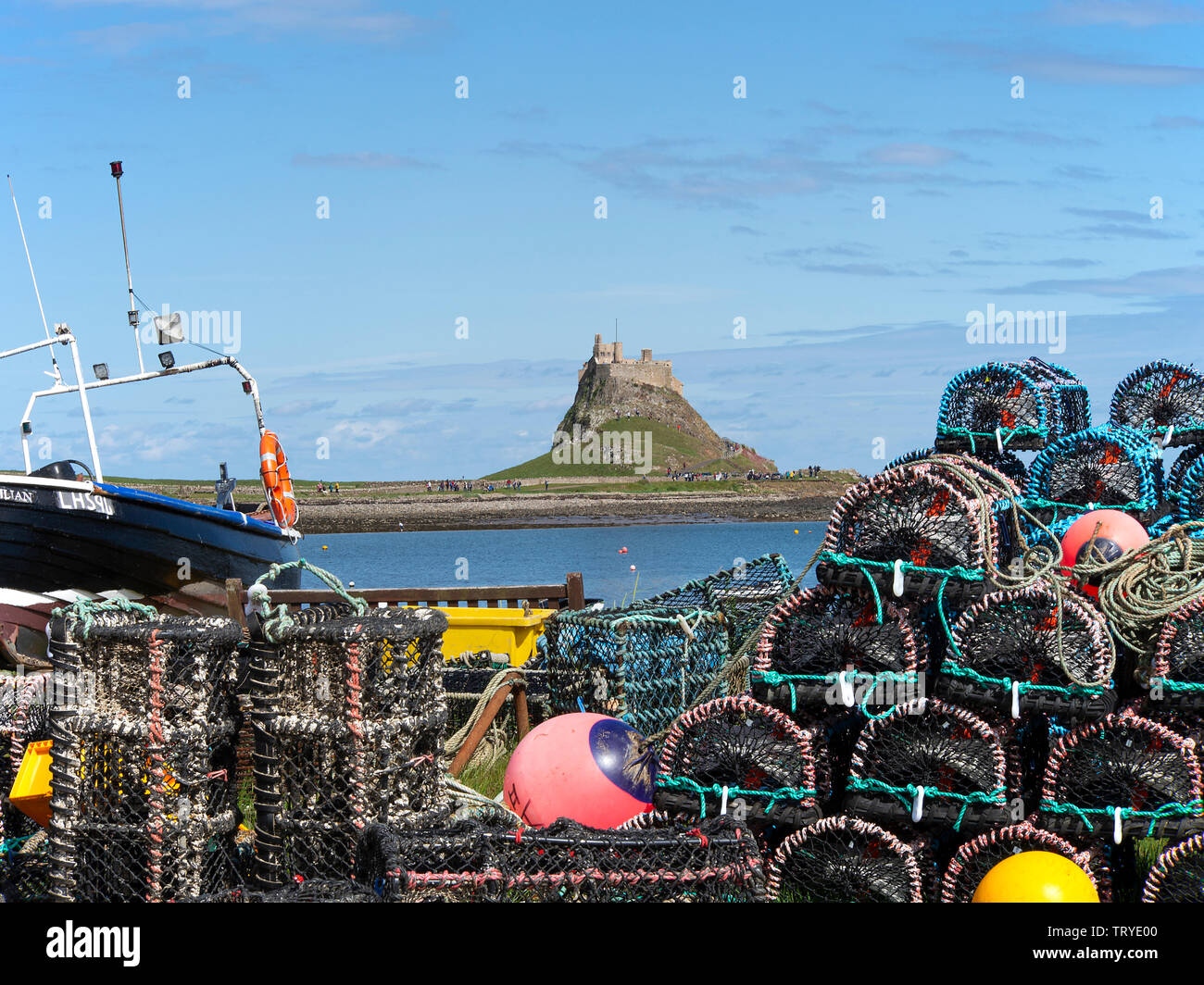 A Fishing Boat and a Pile of Lobster and Crab Pots Frame Lindisfarne ...