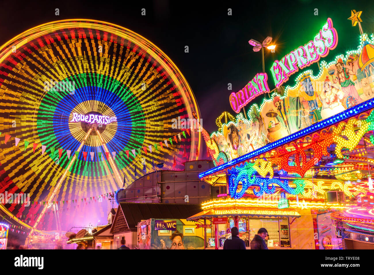Colorful illuminated fairground attractions on funfair in Augsburg ...