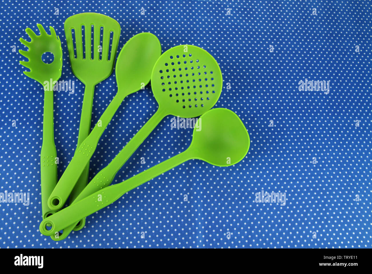 Plastic kitchen utensils on fabric background Stock Photo - Alamy