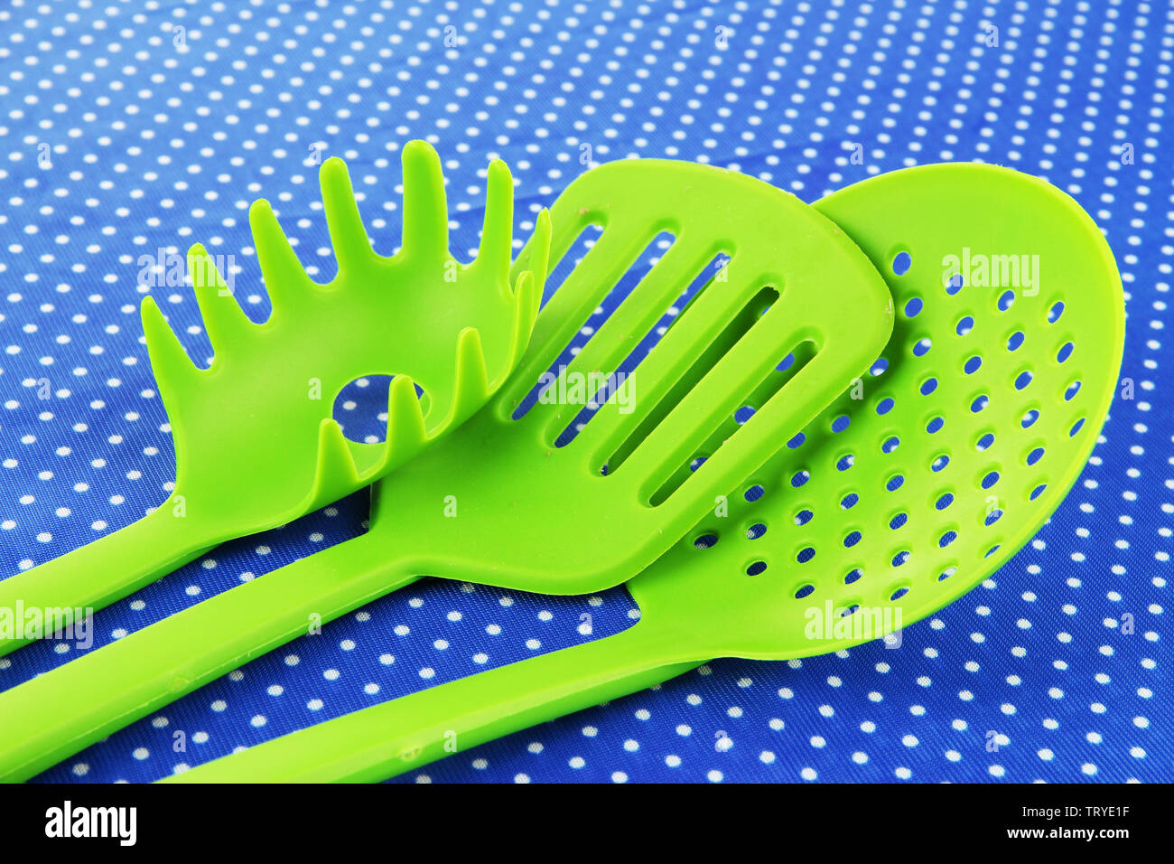 Plastic kitchen utensils on fabric background Stock Photo - Alamy