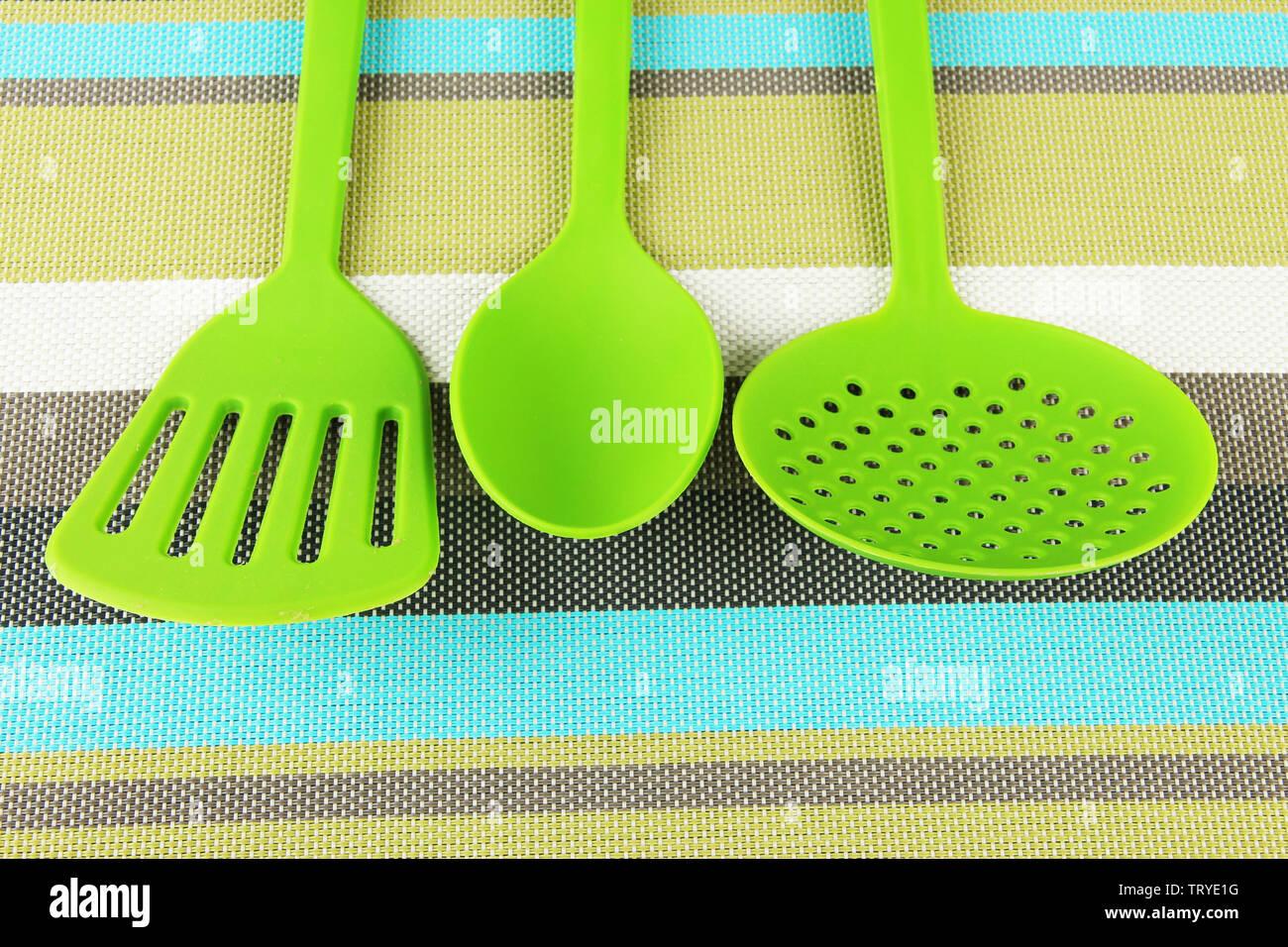 Plastic kitchen utensils on fabric background Stock Photo - Alamy