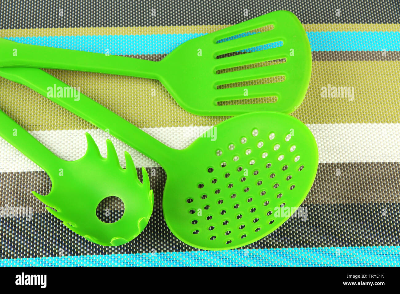 Plastic kitchen utensils on fabric background Stock Photo - Alamy