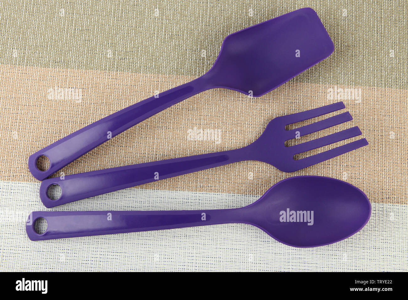 Plastic kitchen utensils on fabric background Stock Photo - Alamy