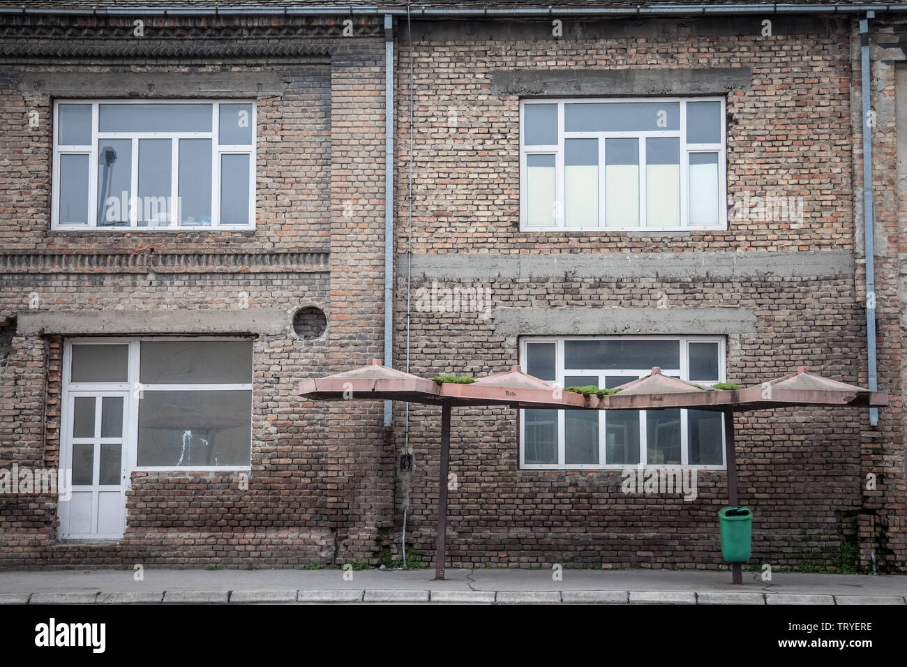 Abandoned bus stop Yugoslav design, in front of a neglected industrial ...