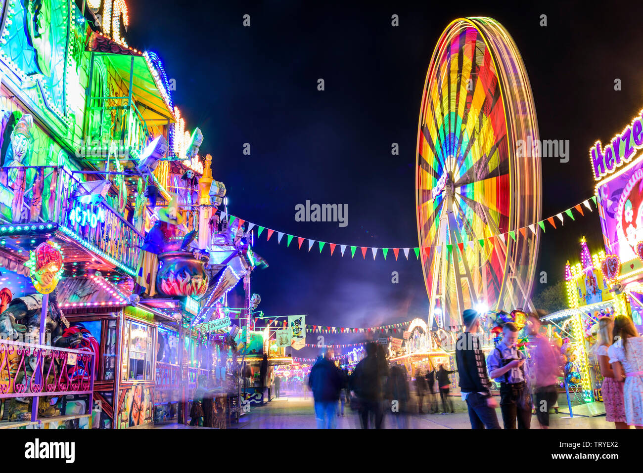 Colorful illuminated fairground attractions on funfair in Augsburg ...