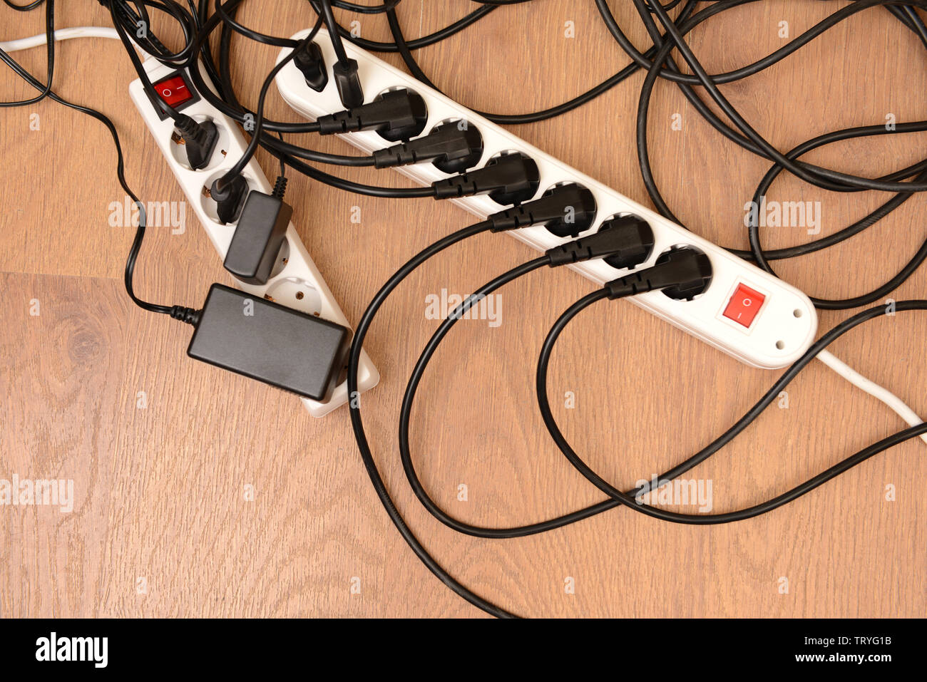 Overloaded power boards, on wooden floor background Stock Photo - Alamy