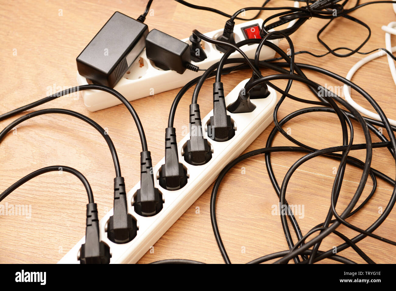 Overloaded power boards, on wooden floor background Stock Photo - Alamy