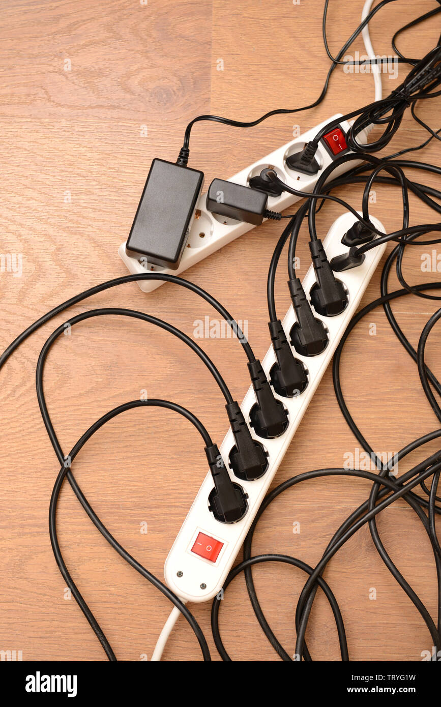 Overloaded power boards, on wooden floor background Stock Photo - Alamy
