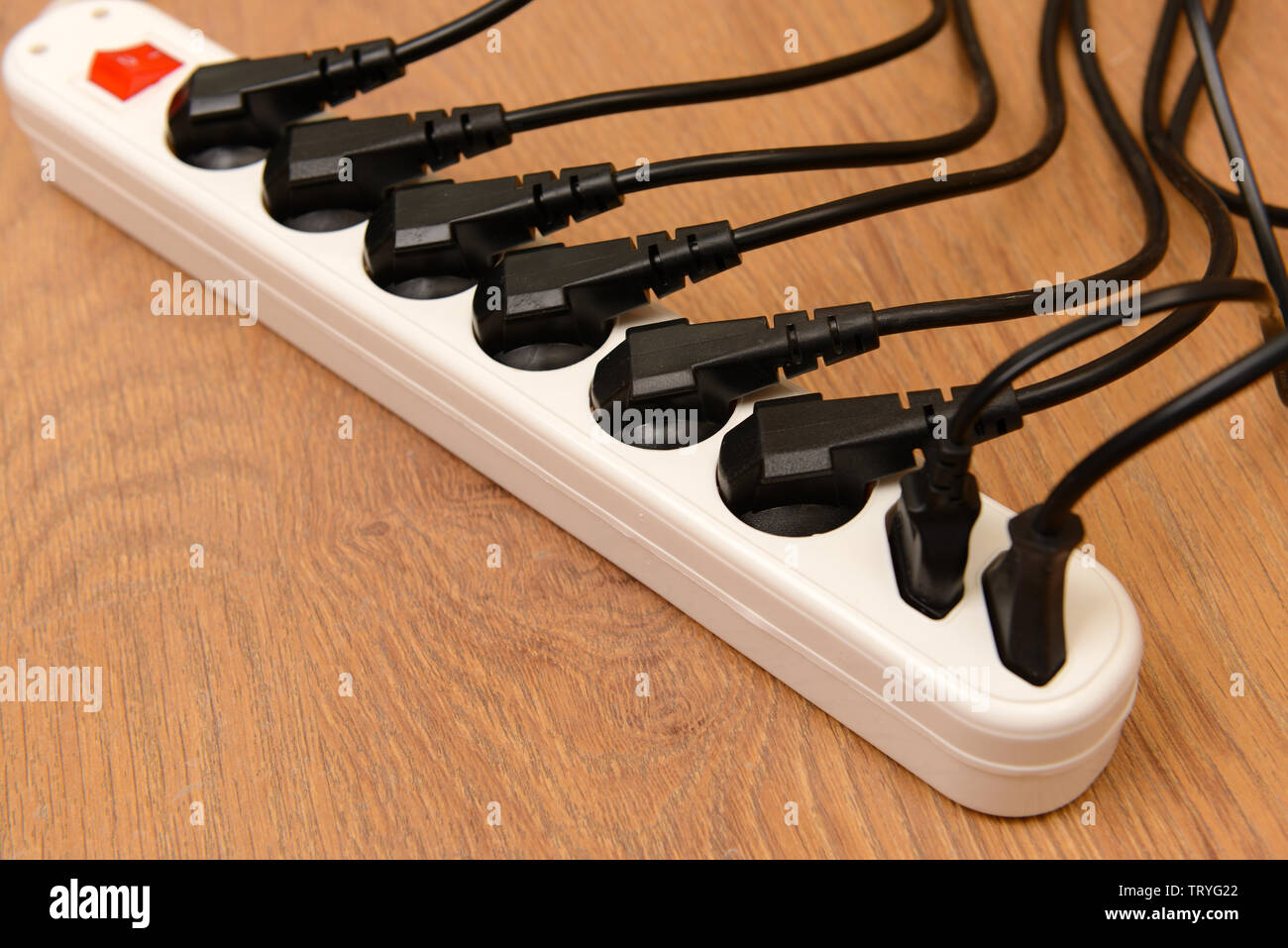Overloaded power board, on wooden floor background Stock Photo - Alamy