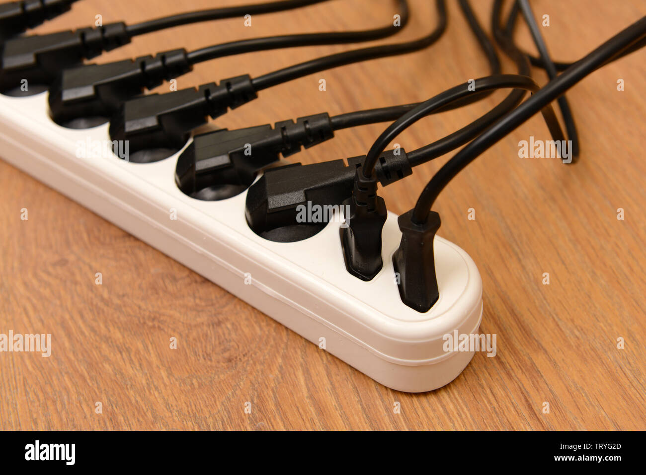 Overloaded power board, on wooden floor background Stock Photo - Alamy