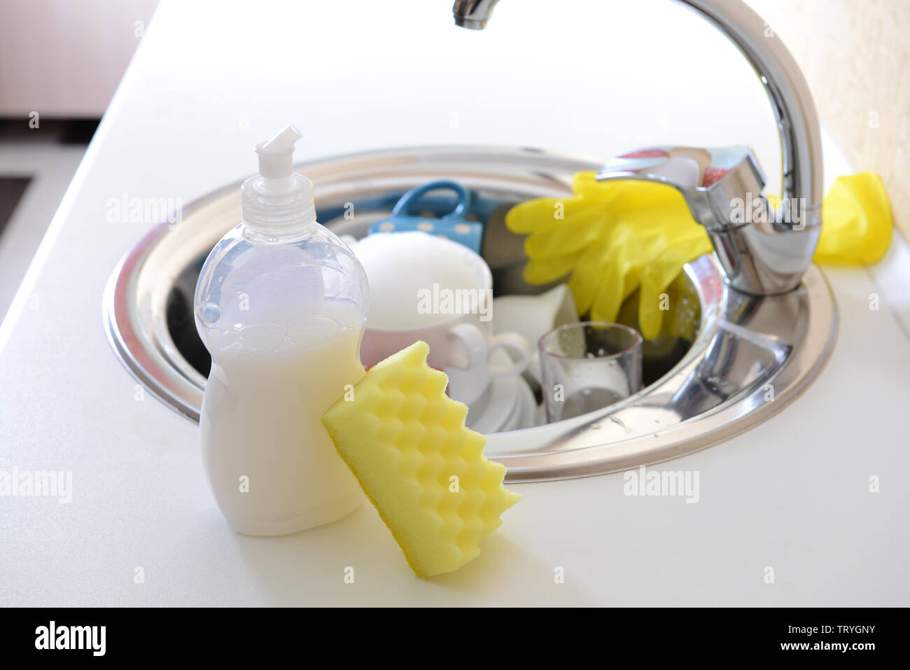 Stack of dishes soaking in kitchen sink Stock Photo - Alamy