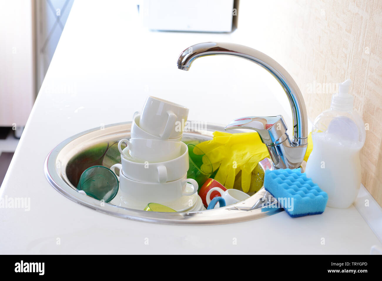 Stack of dishes soaking in kitchen sink Stock Photo - Alamy