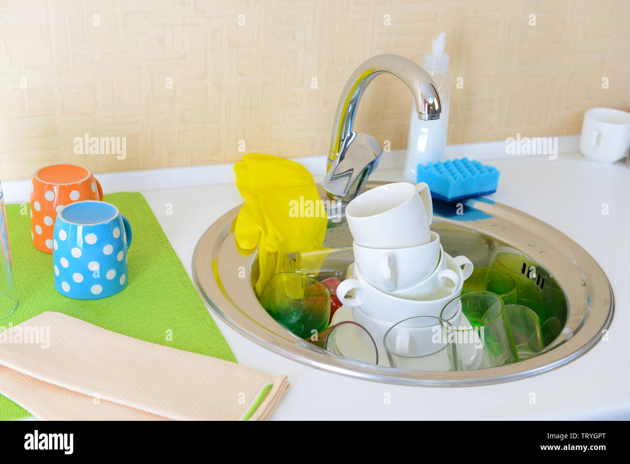 Stack of dishes soaking in kitchen sink Stock Photo - Alamy