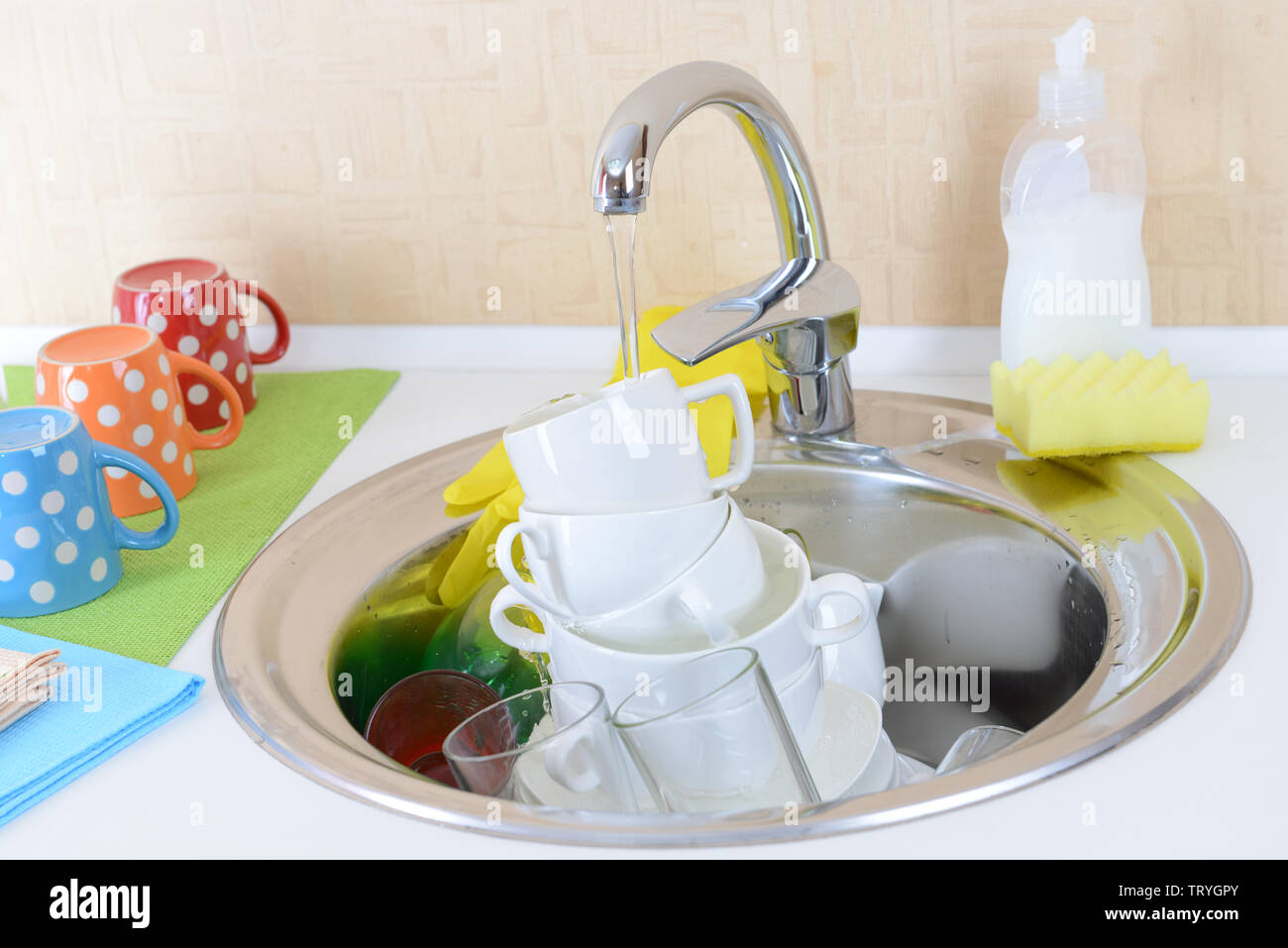Stack of dishes soaking in kitchen sink Stock Photo - Alamy