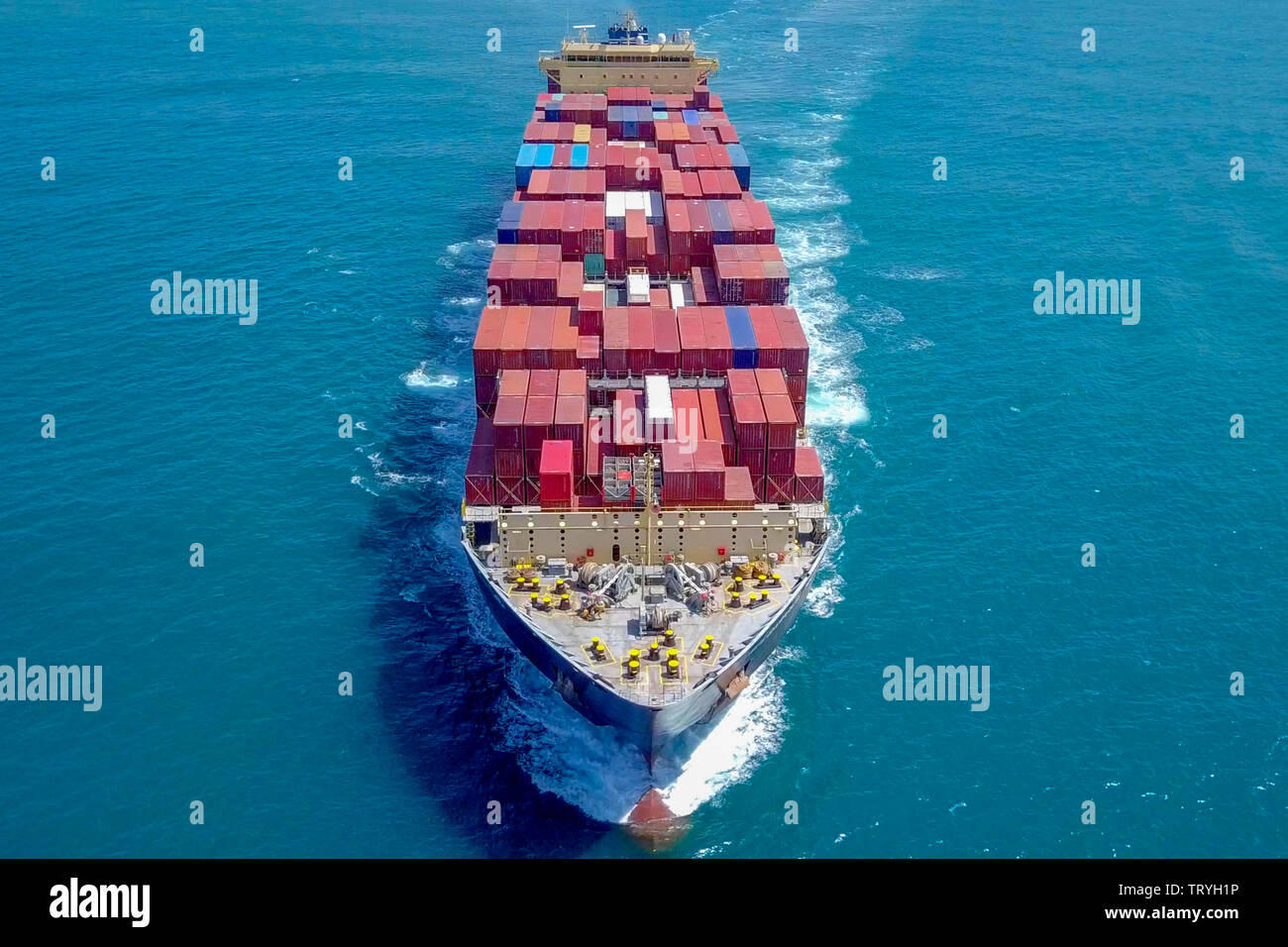 Aerial image of a large container ship at sea, loaded with various ...