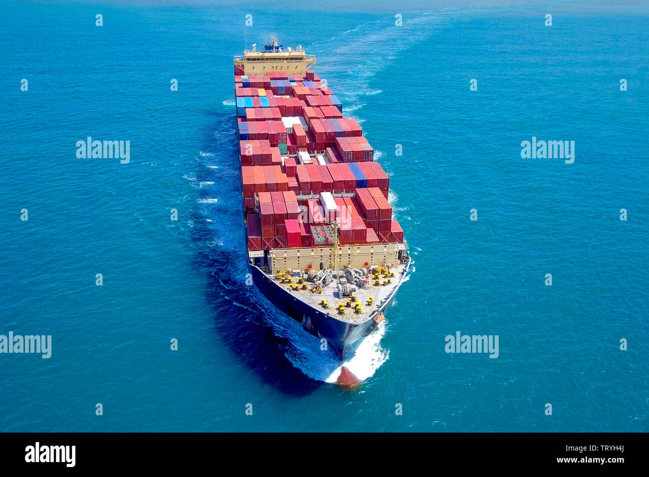 Aerial image of a large container ship at sea, loaded with various ...